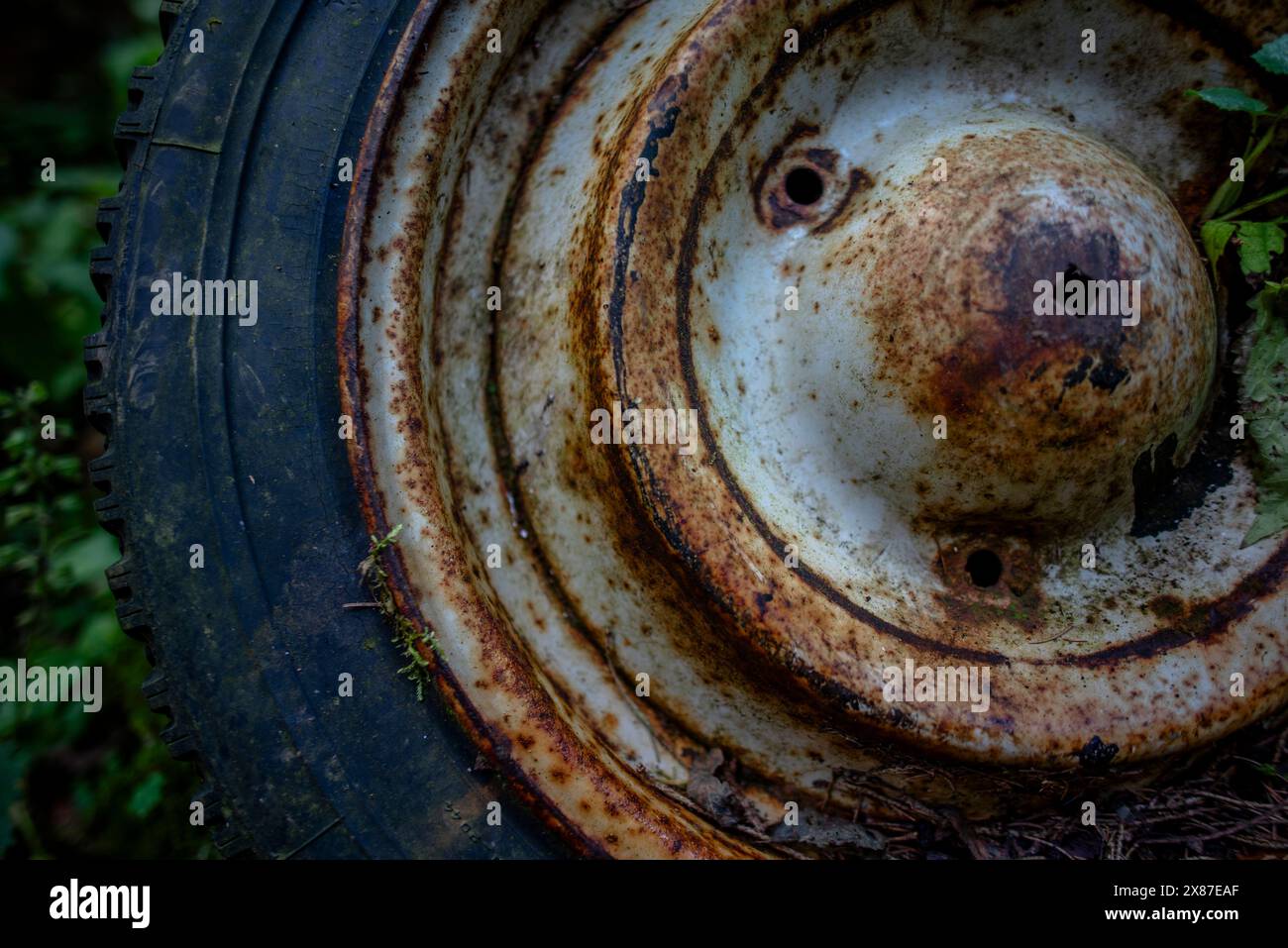 close-up of an old car wheel with a ruined black tire and rusty rim ...