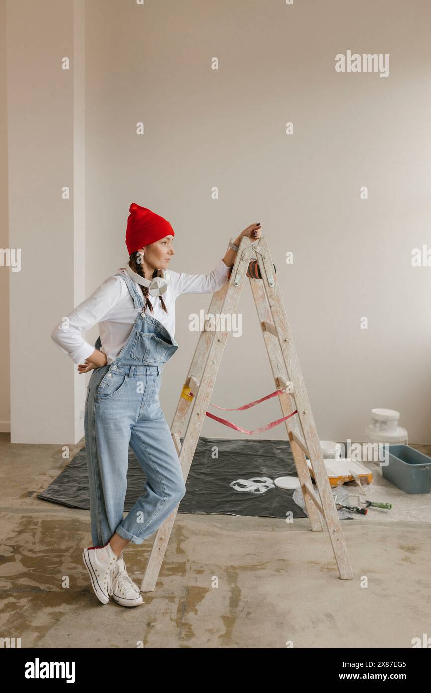 Woman with legs crossed leaning on ladder in new apartment Stock Photo ...
