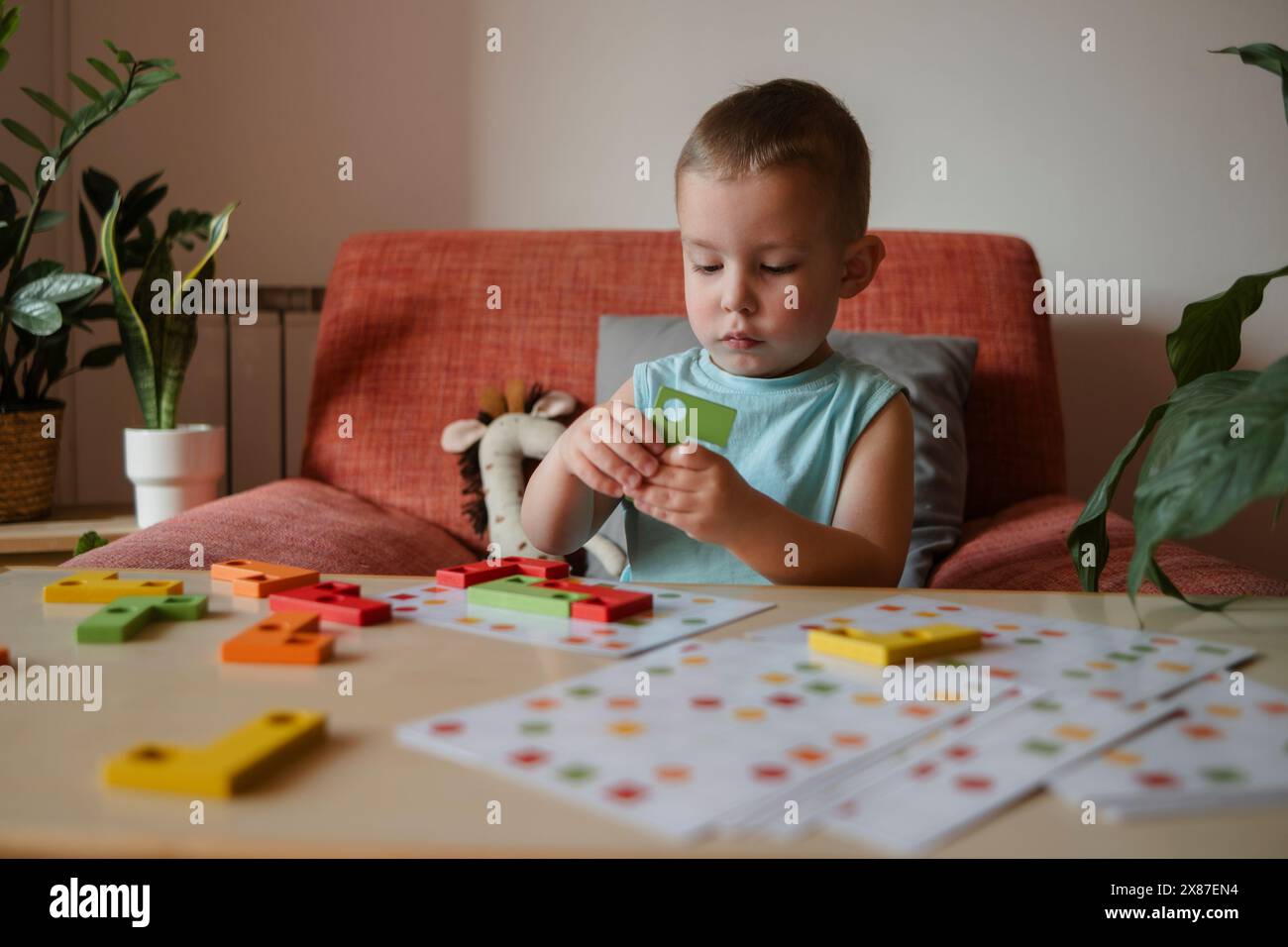 Boy solving puzzle game on table at home Stock Photo - Alamy