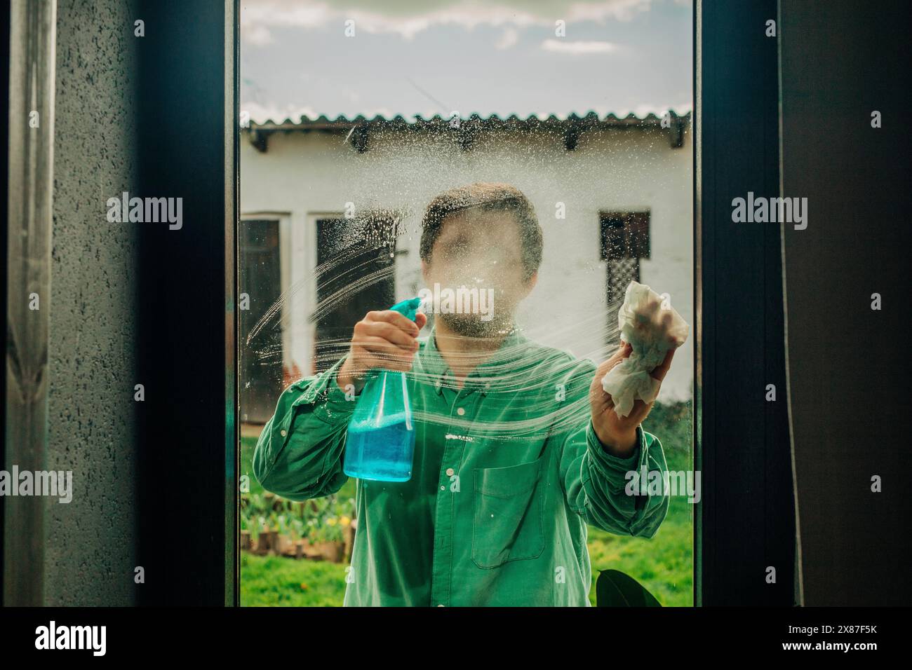 Man cleaning window with soap solution Stock Photo - Alamy
