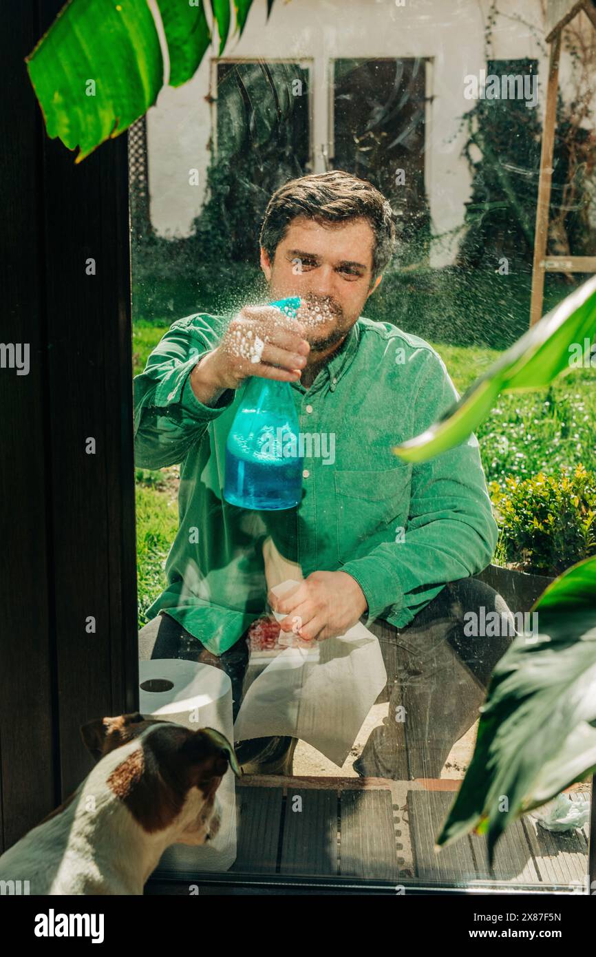 Man spraying liquid soap on glass window Stock Photo - Alamy