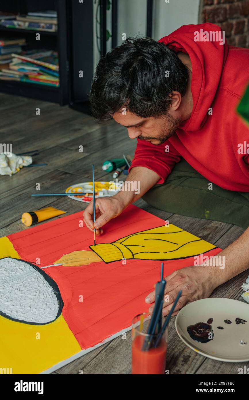 Focused painter painting with brush on canvas at home Stock Photo - Alamy