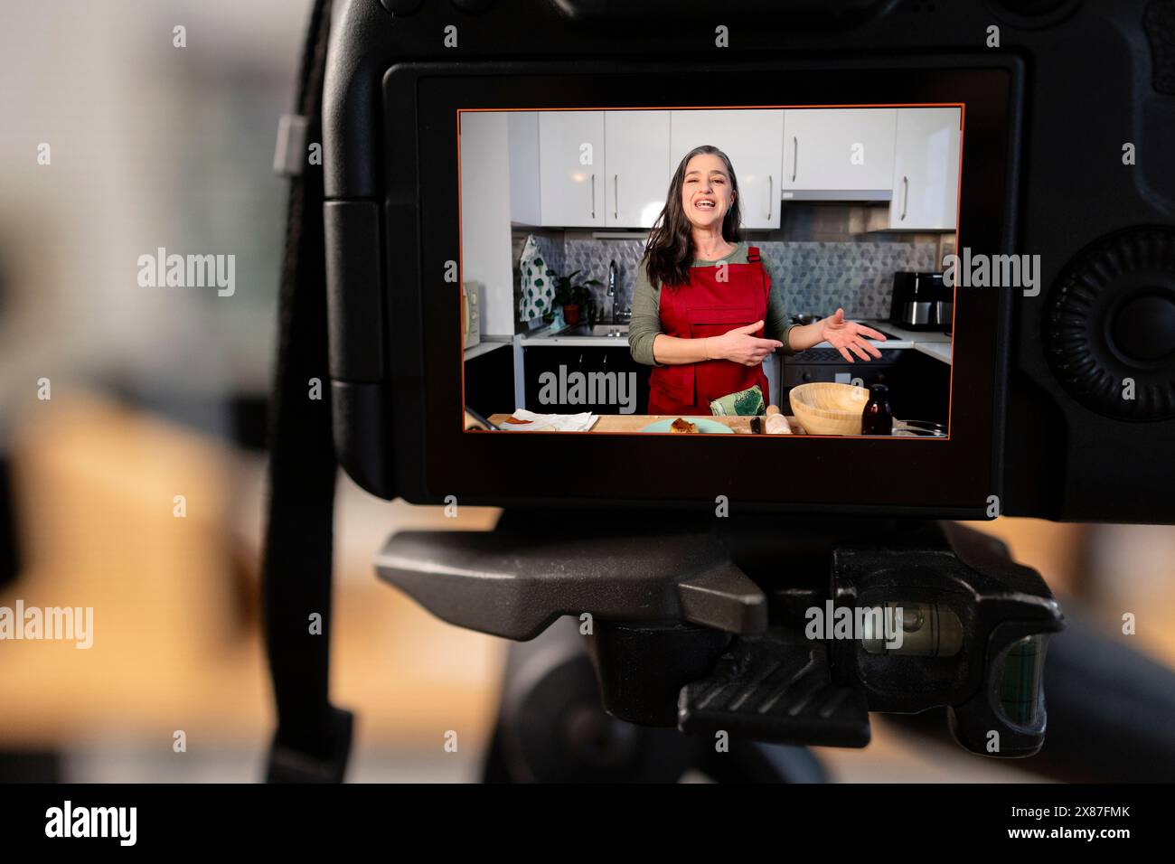 Smiling mature woman vlogging seen through camera display screen Stock ...