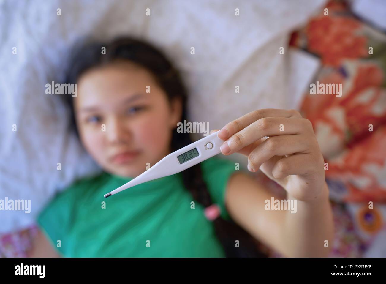 Sick girl showing temperature on thermometer at home Stock Photo - Alamy