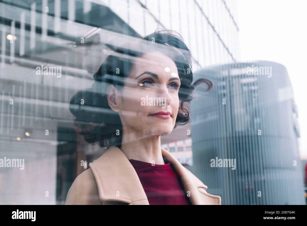 Focused businesswoman behind glass window Stock Photo - Alamy