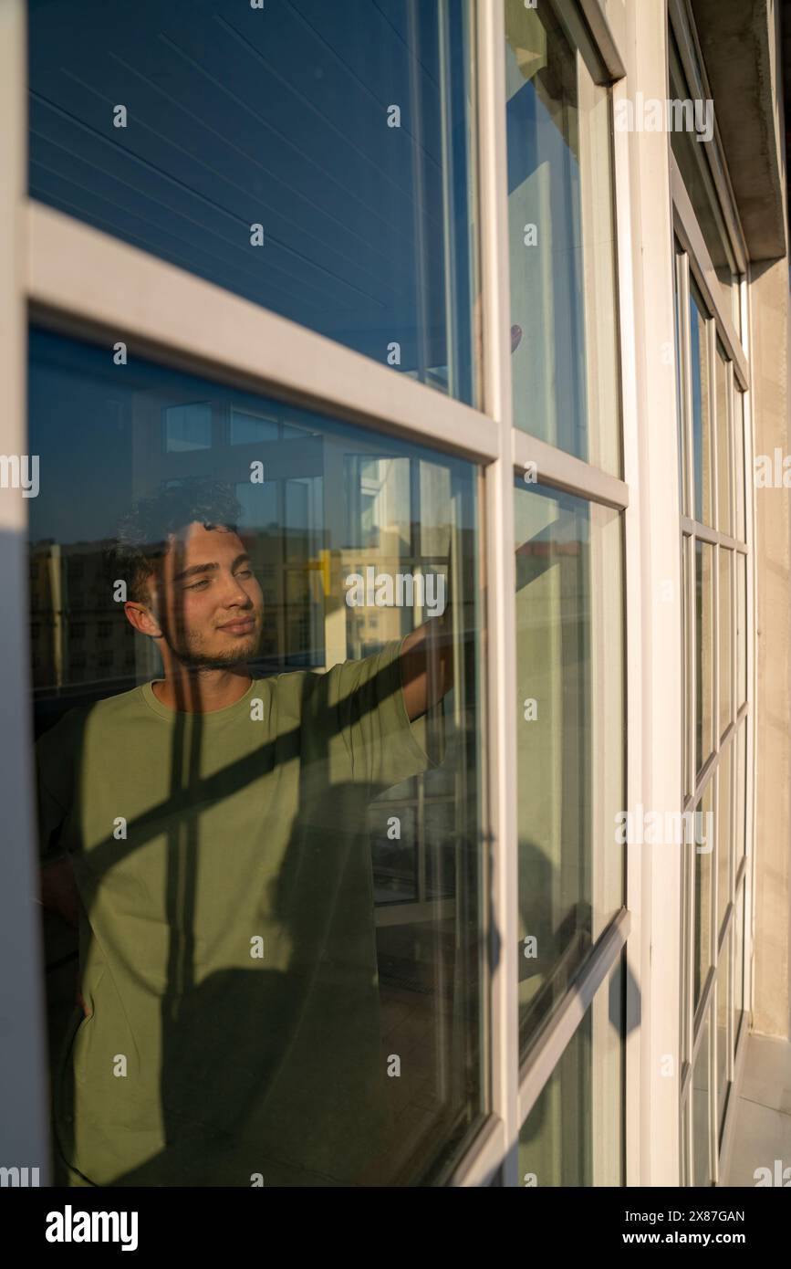 Young man seen through window on sunny day Stock Photo - Alamy