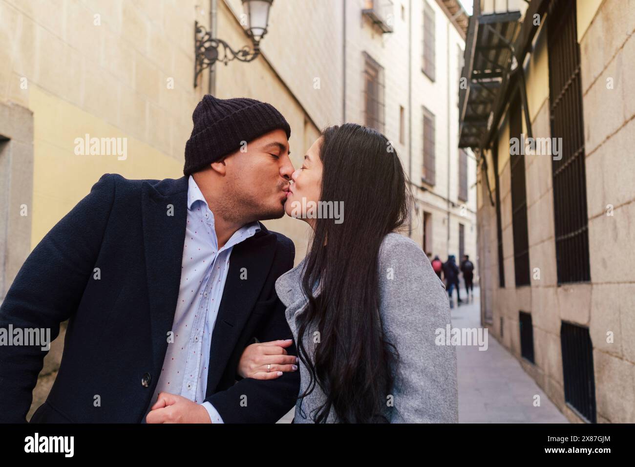 Romantic couple kissing amidst buildings Stock Photo - Alamy