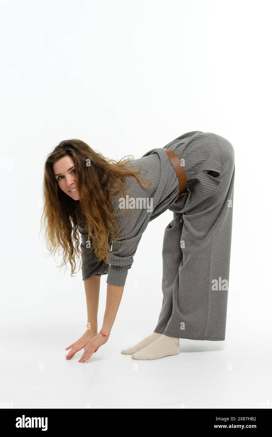 A young attractive woman doing body bends on a white background Stock ...
