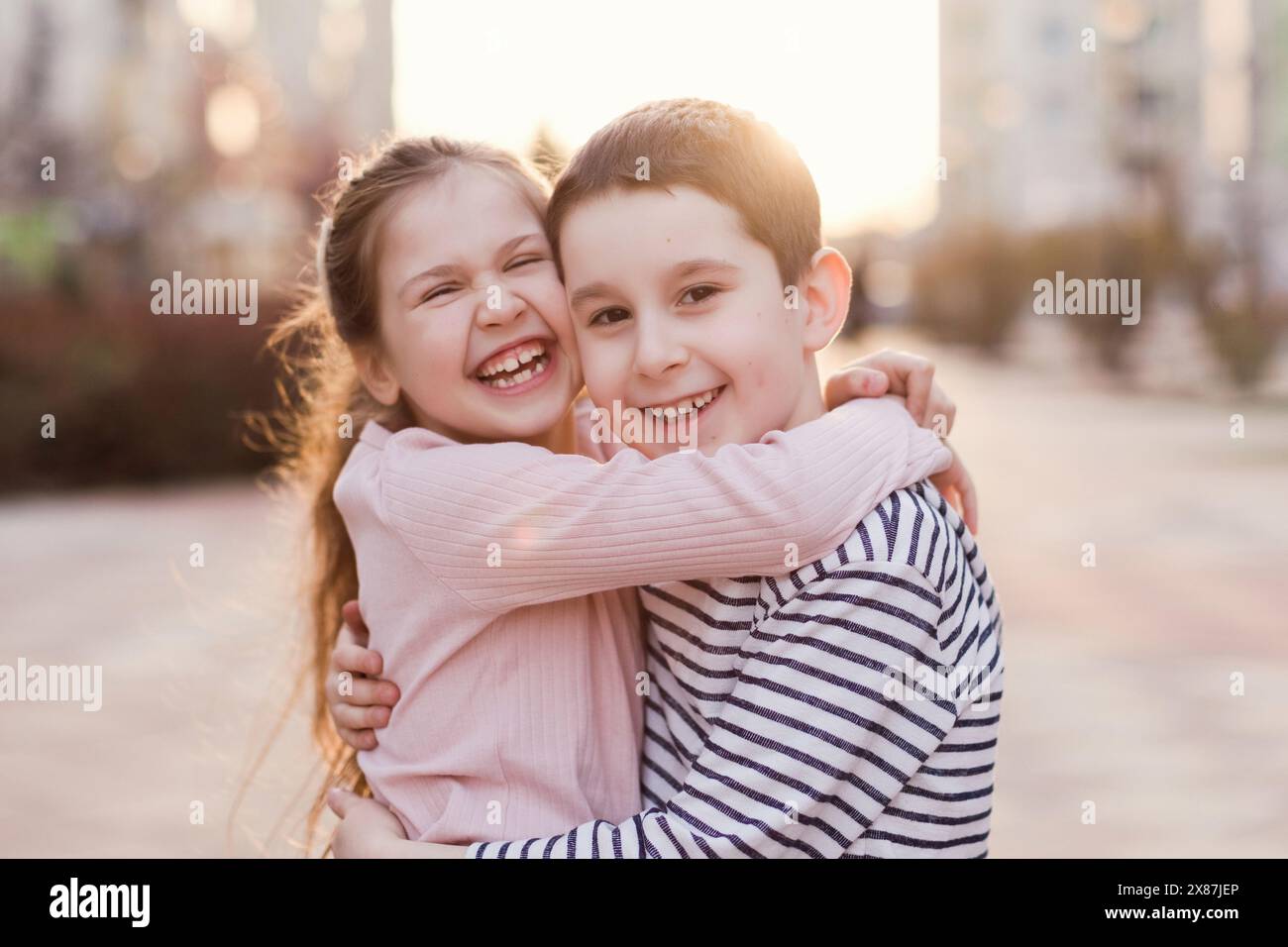Cheerful siblings embracing each other Stock Photo - Alamy