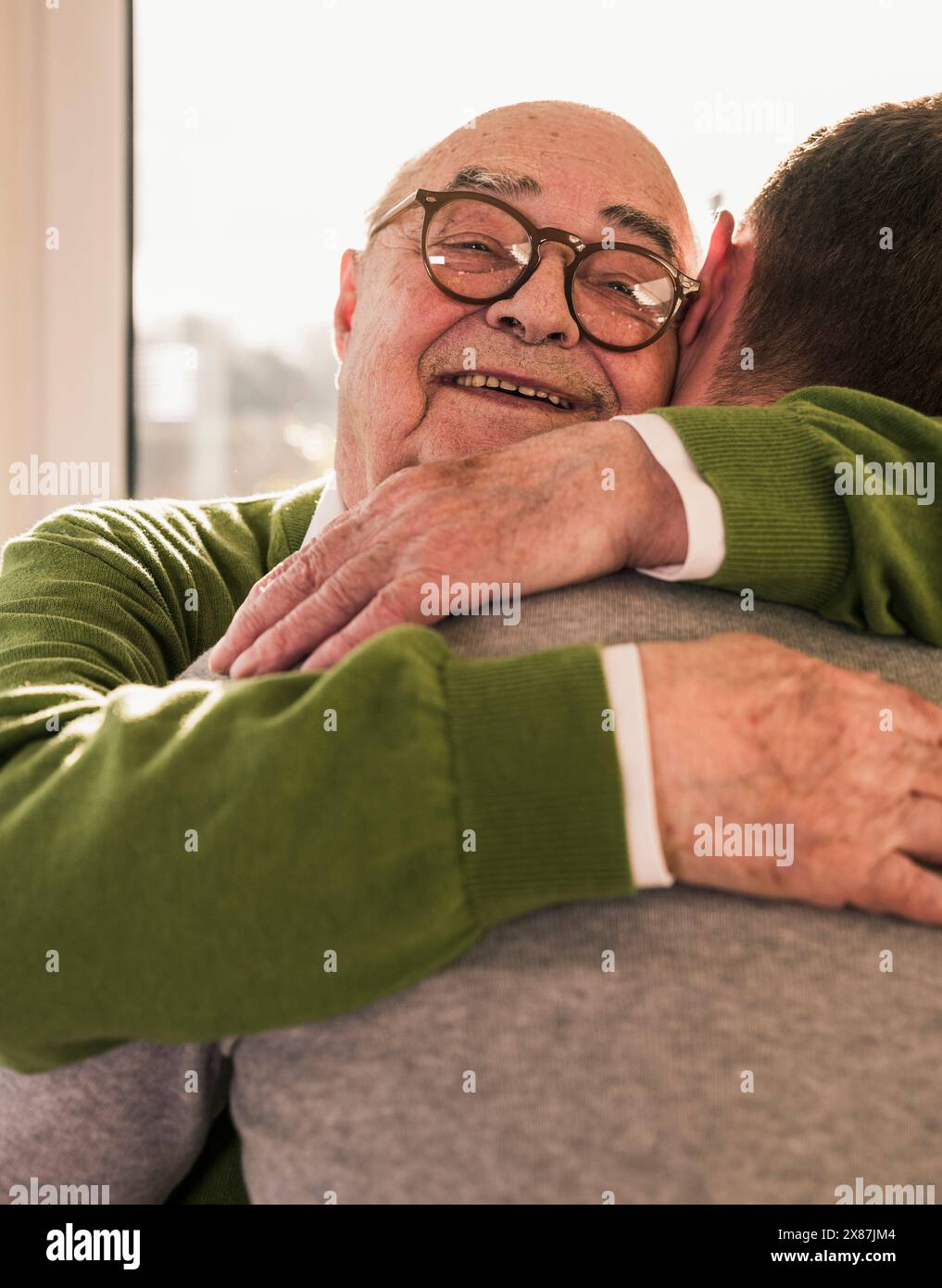 Happy senior man hugging man at nursing home Stock Photo - Alamy