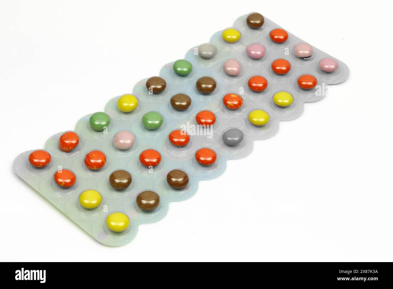 Colorful chocolate filled tablet pills candies in blister isolated on ...