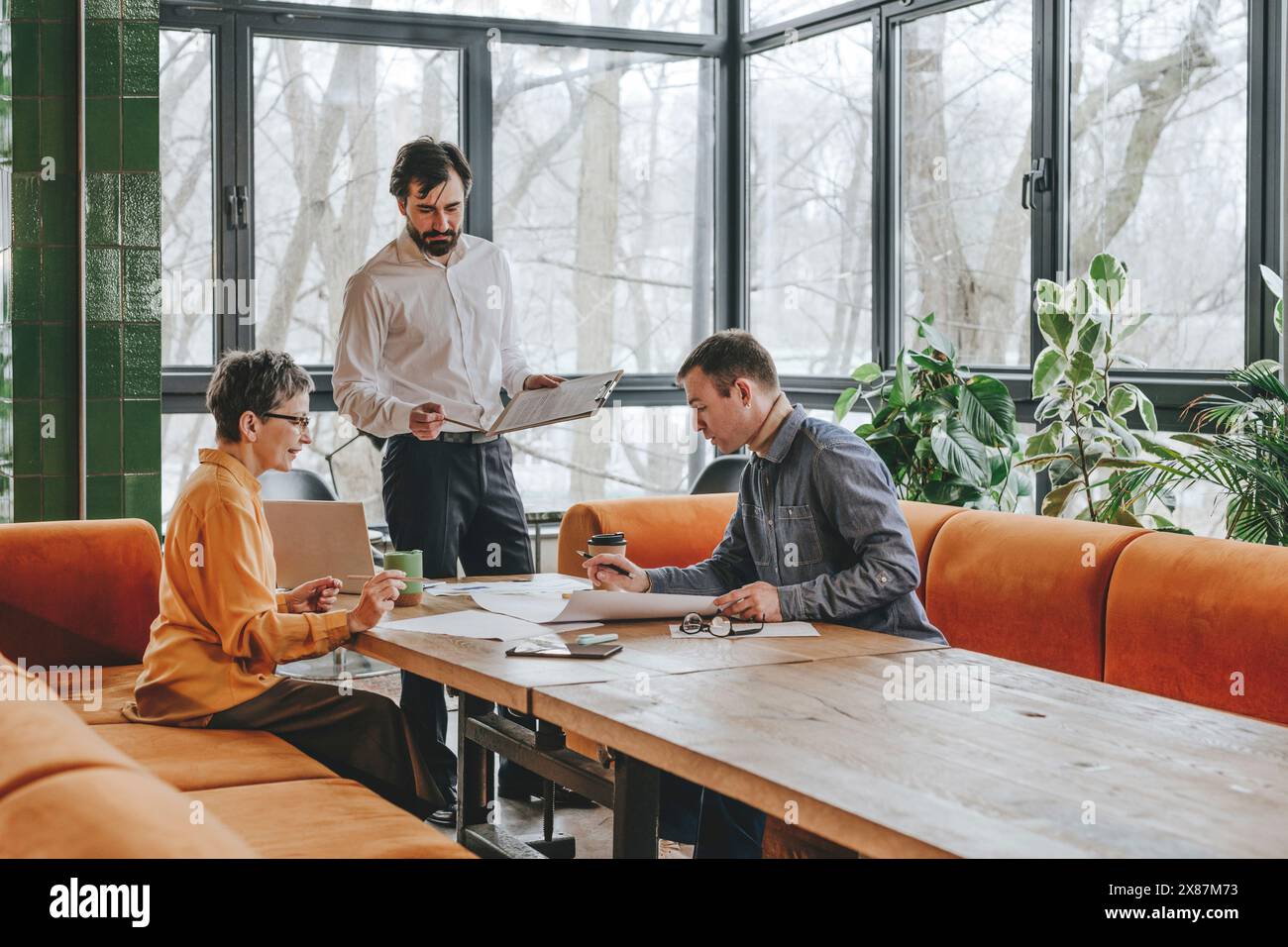 Business people having discussion over project in office Stock Photo ...