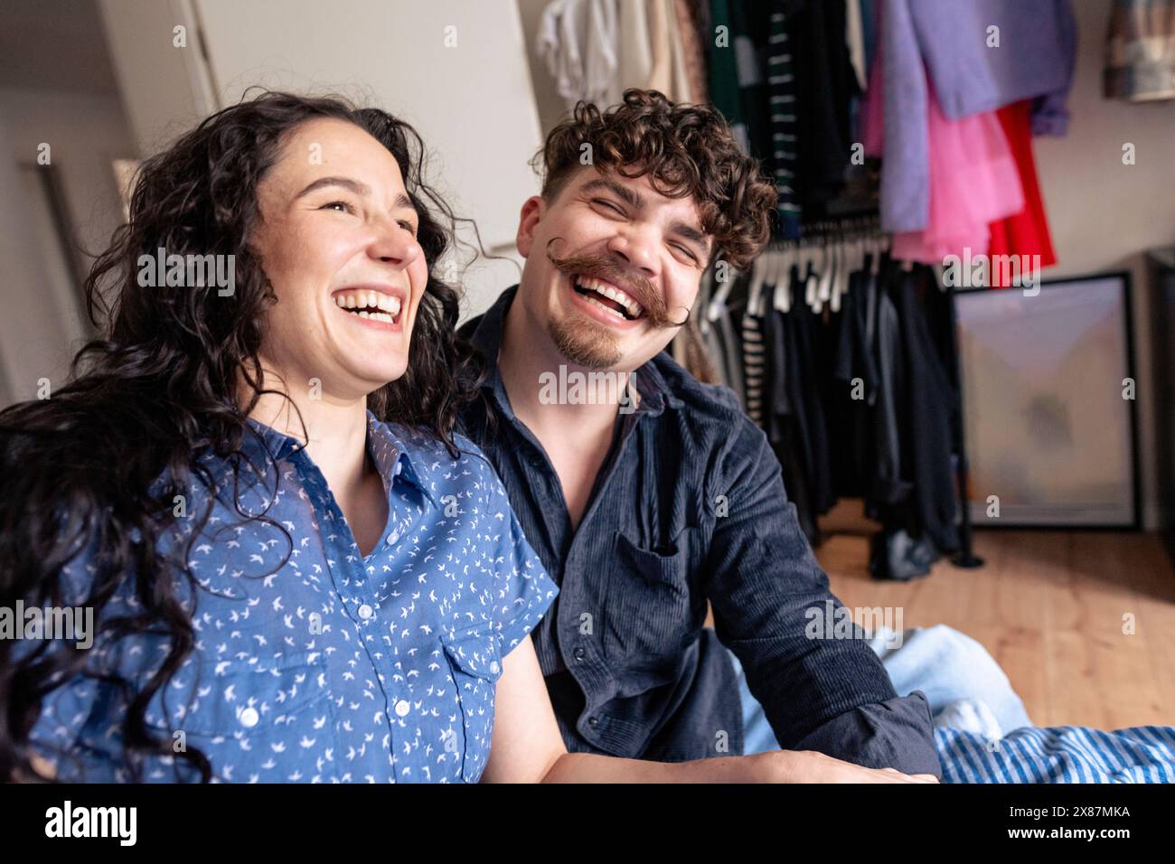 Cheerful couple laughing at home Stock Photo - Alamy