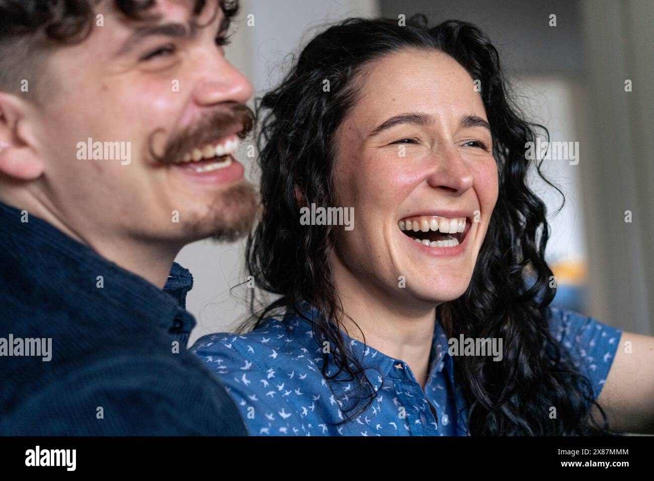 Happy woman laughing with boyfriend at home Stock Photo - Alamy