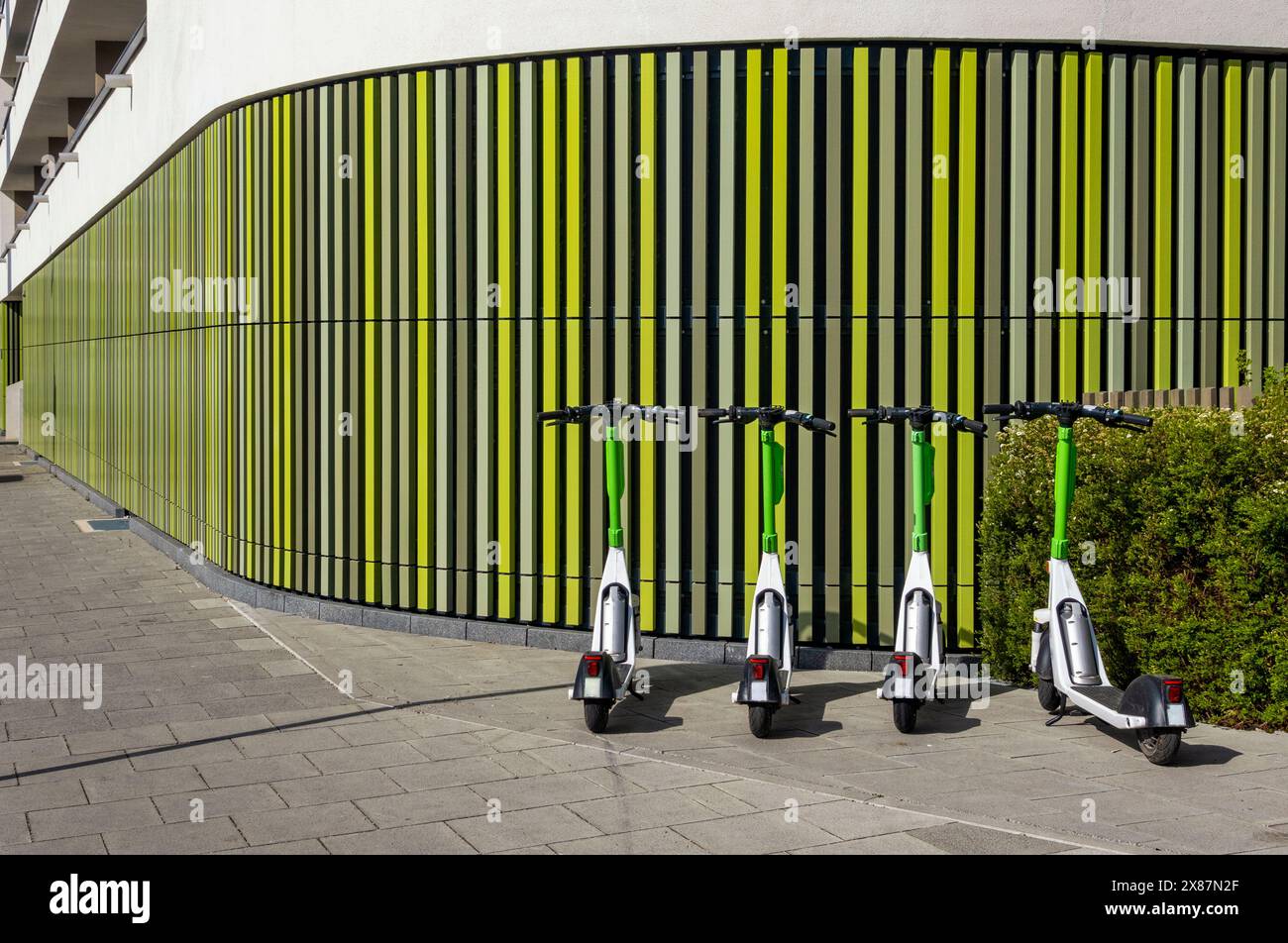 Germany, Bavaria, Munich, Electric push scooters standing on sidewalk ...