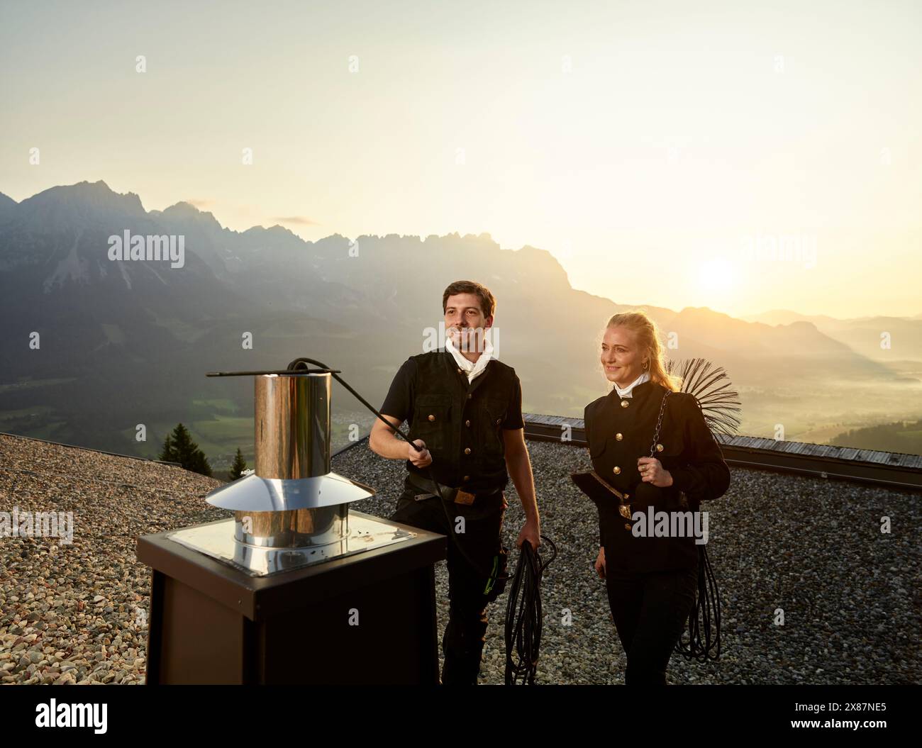 Chimney sweepers cleaning chimney on rooftop at sunrise Stock Photo - Alamy