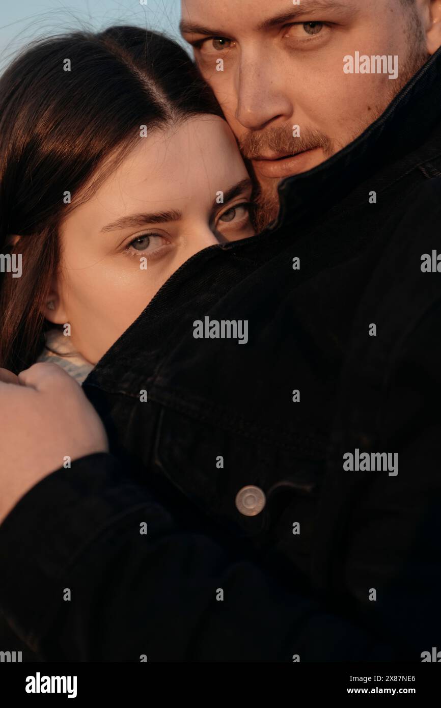 Woman hiding face behind man's jacket Stock Photo - Alamy