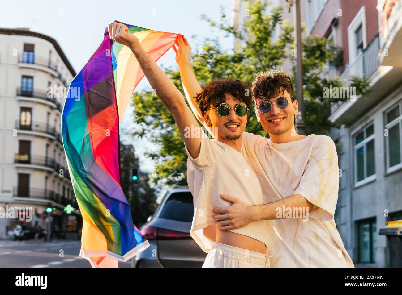 Happy young couple waving rainbow flag at gay pride parade Stock Photo ...