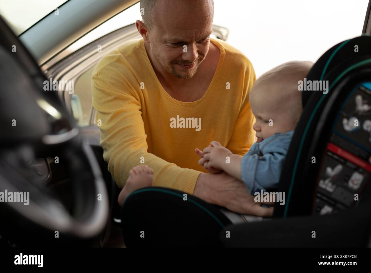 Father fastening seat belt for son sitting in car Stock Photo - Alamy