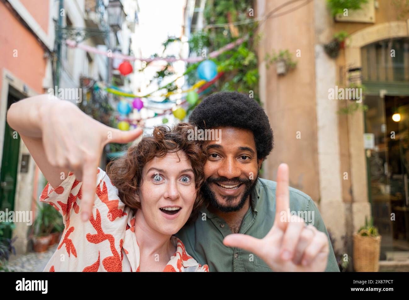 Woman making finger frame with boyfriend near buildings Stock Photo - Alamy