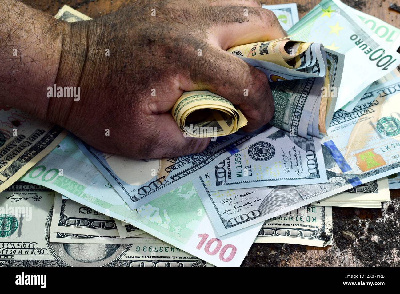 Man's hand smeared with dirt, a symbol of theft, squeezes illegally ...