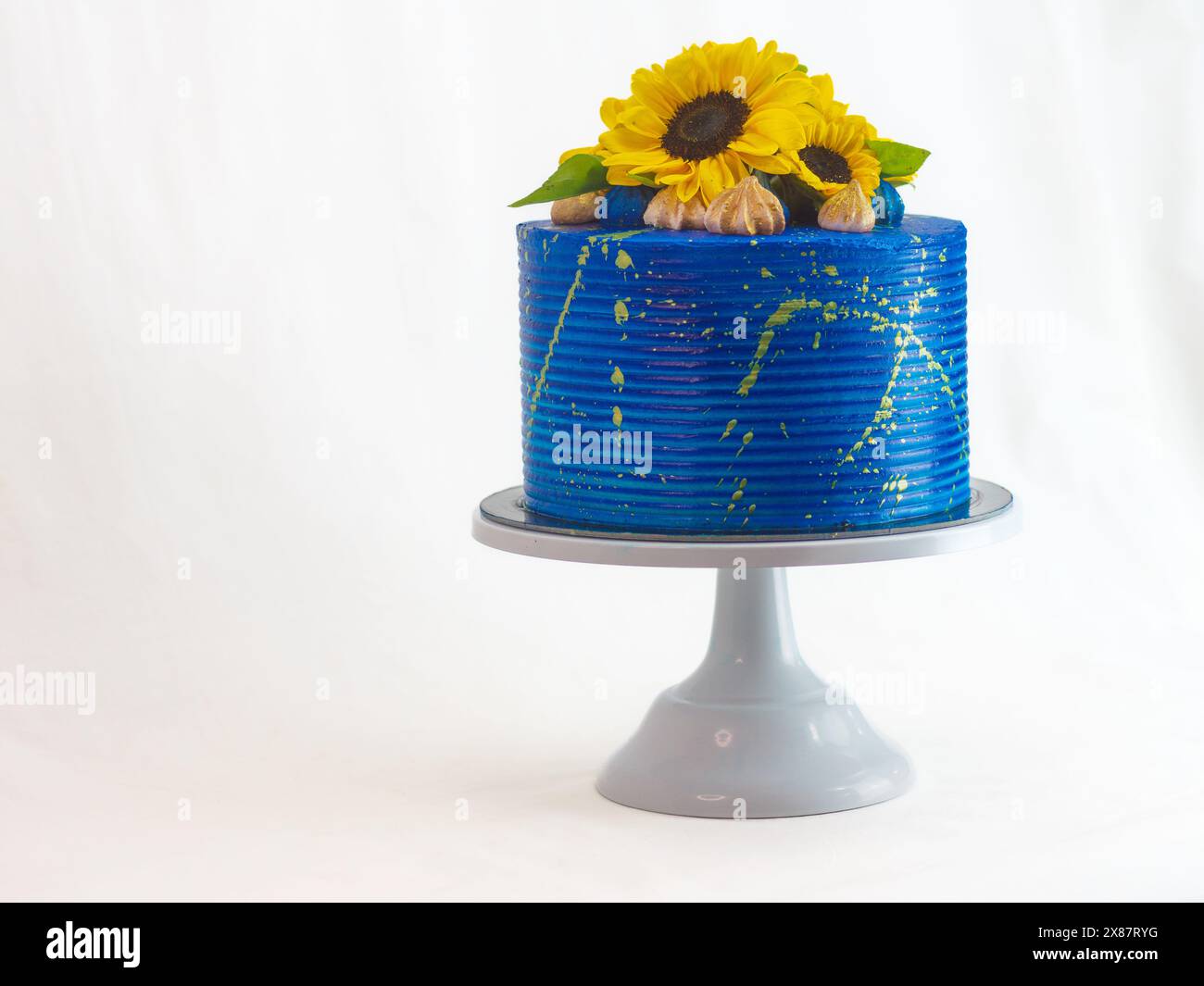 Stunning cake with bright blue icing, adorned with fresh sunflowers and ...