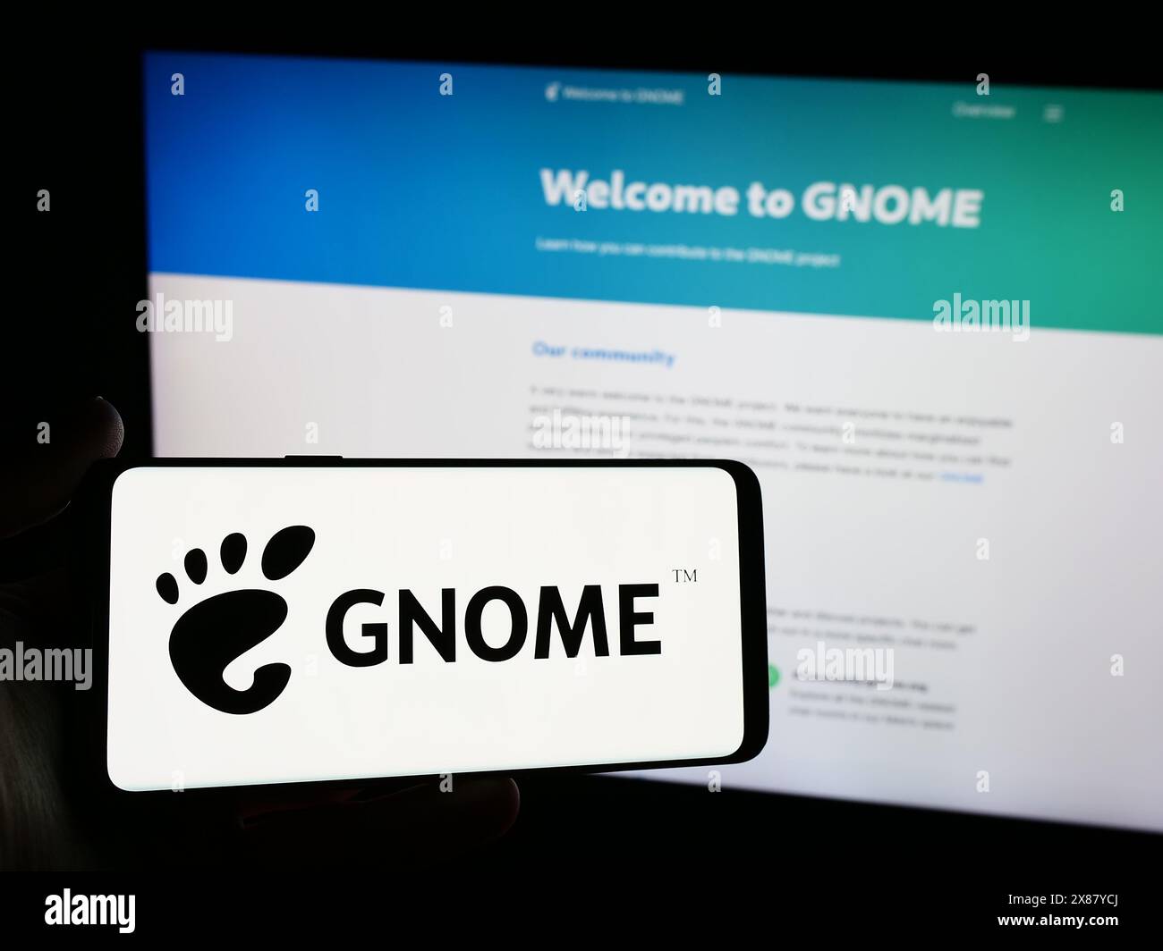 Person holding smartphone with logo of open-source GNU Network Object ...