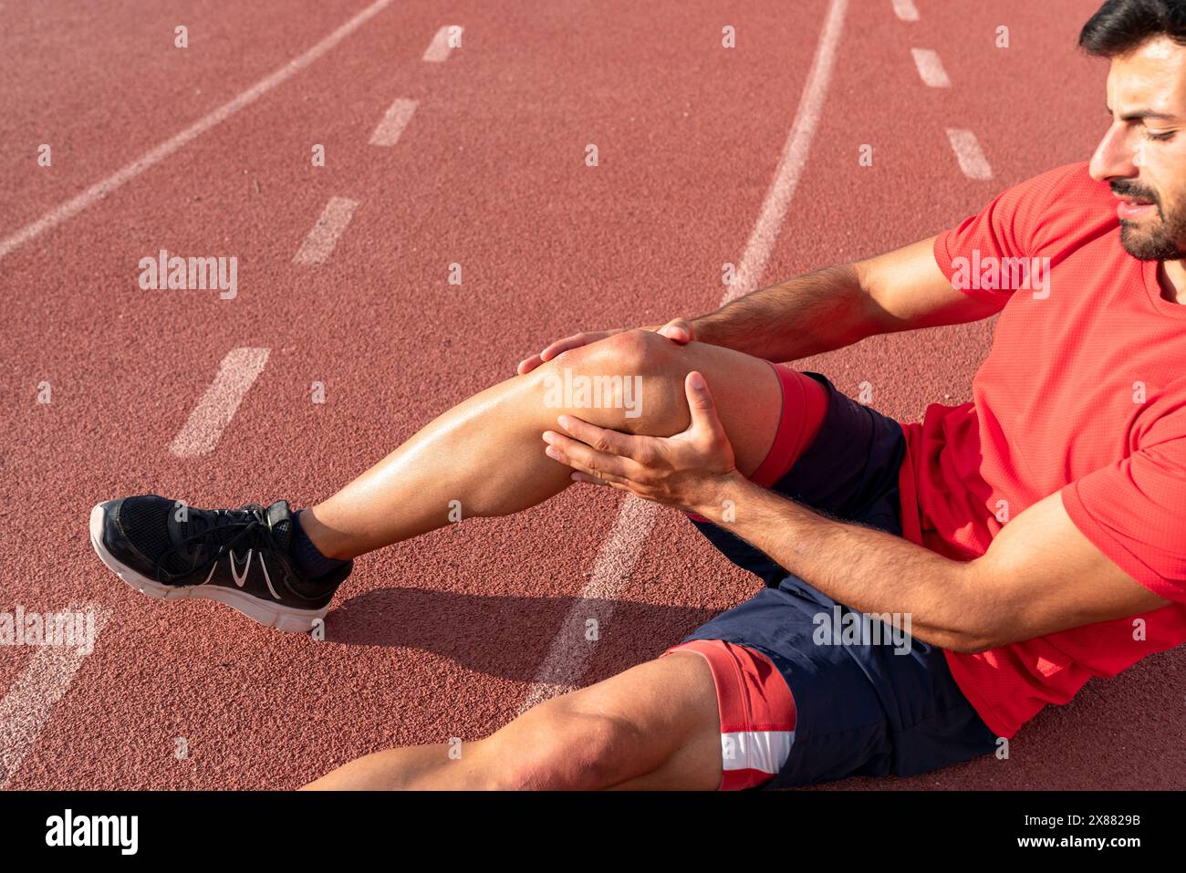 An athlete with an injured knee is holding his knee. knee and joint ...