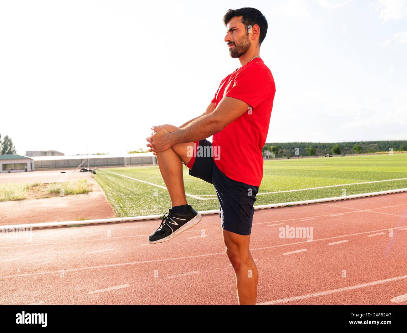Athlete warming up by stretching before exercise. man doing stretching ...
