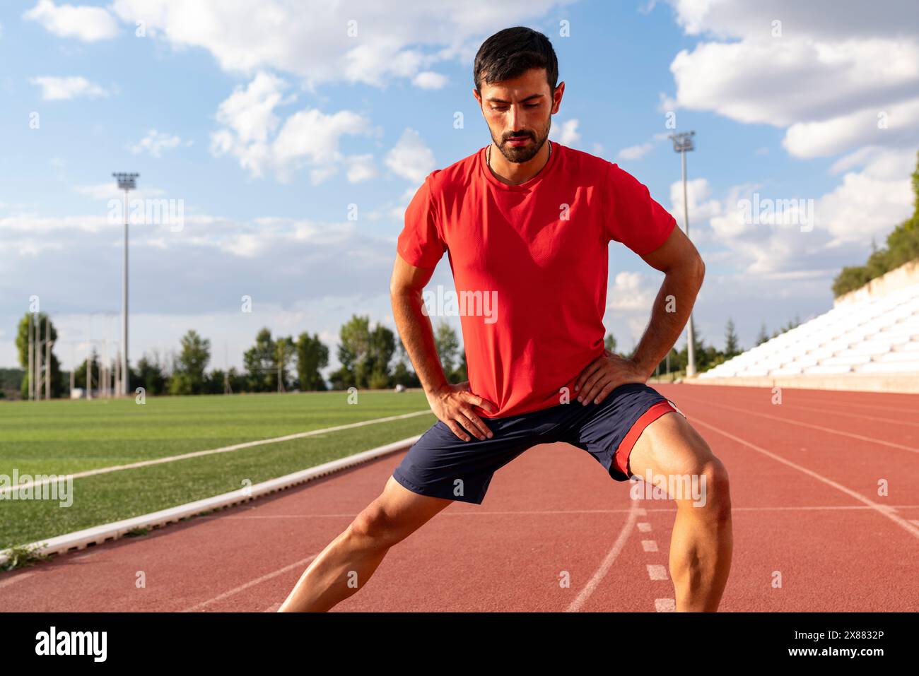 Athlete warming up by stretching before exercise. man doing stretching ...