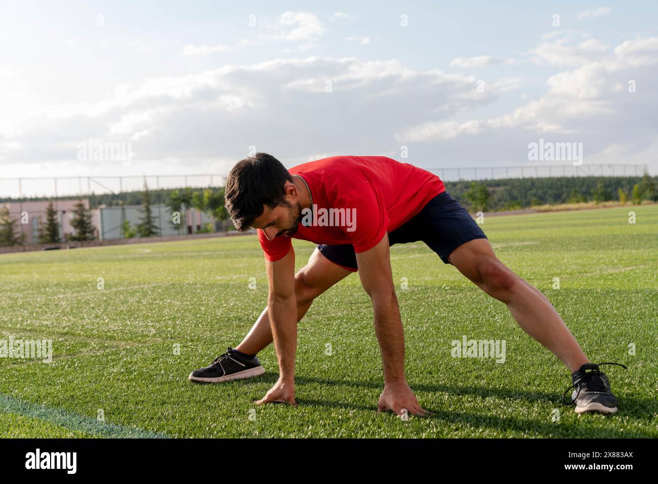 Athlete warming up by stretching before exercise. man doing stretching ...