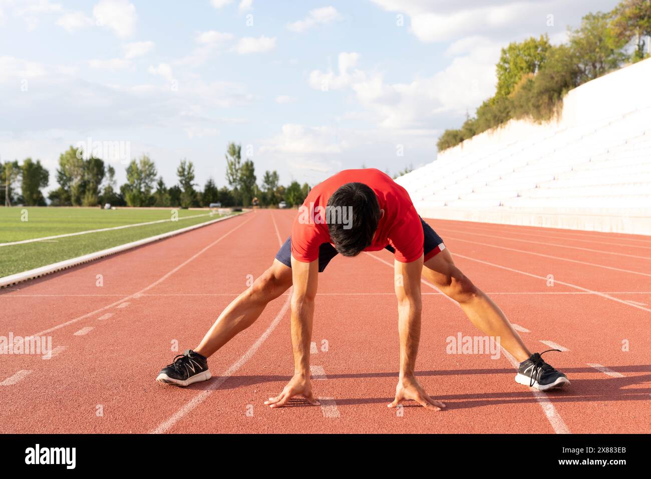Athlete warming up by stretching before exercise. man doing stretching ...