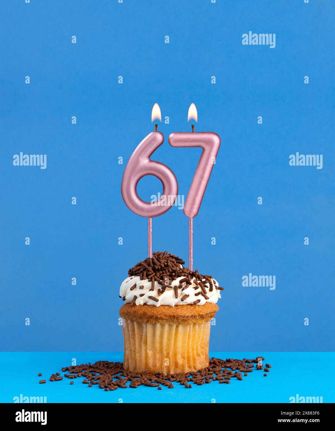 Birthday candle with cupcake on blue background - Number 67 Stock Photo ...