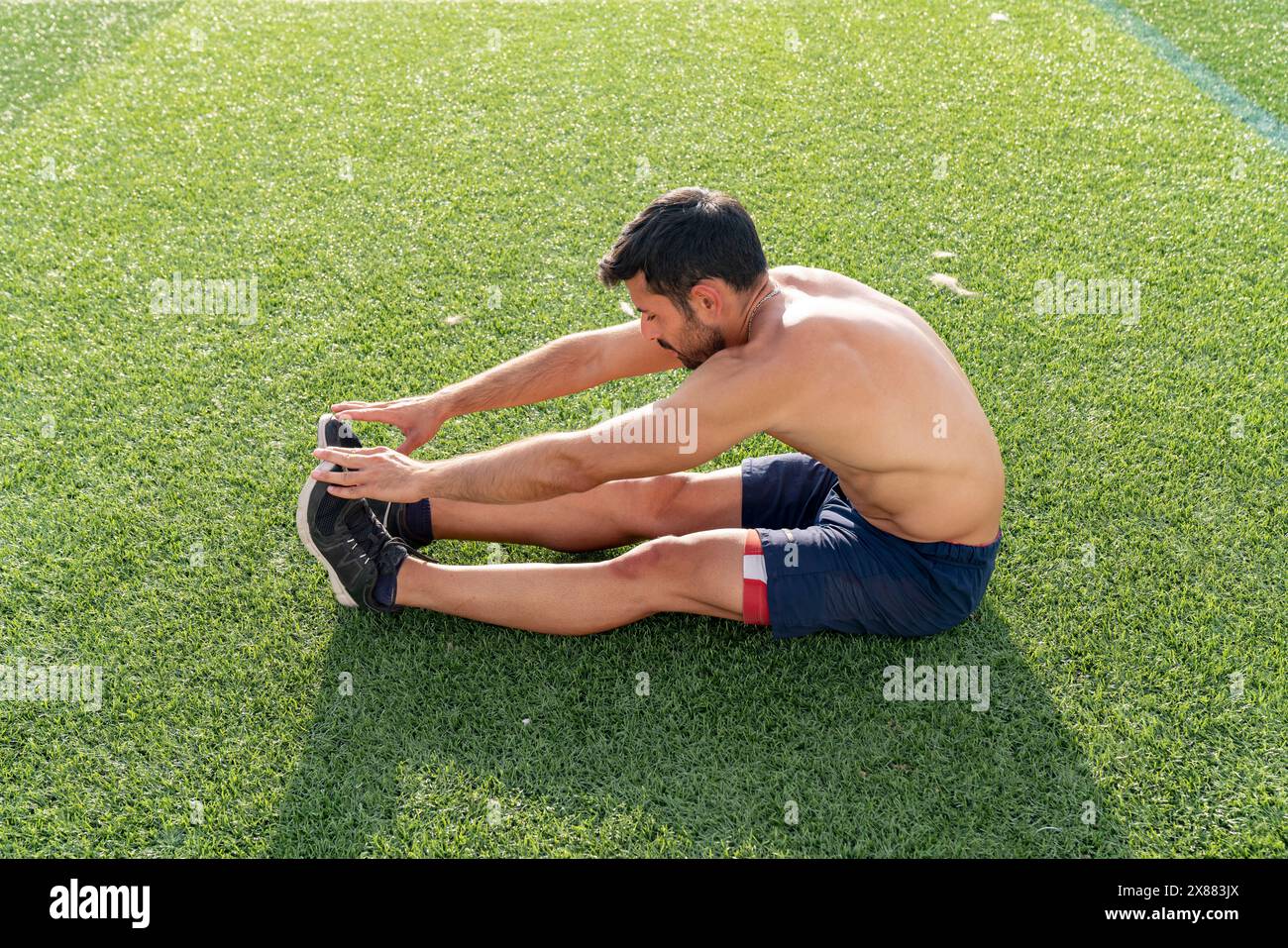 Athlete warming up by stretching before exercise. man doing stretching ...