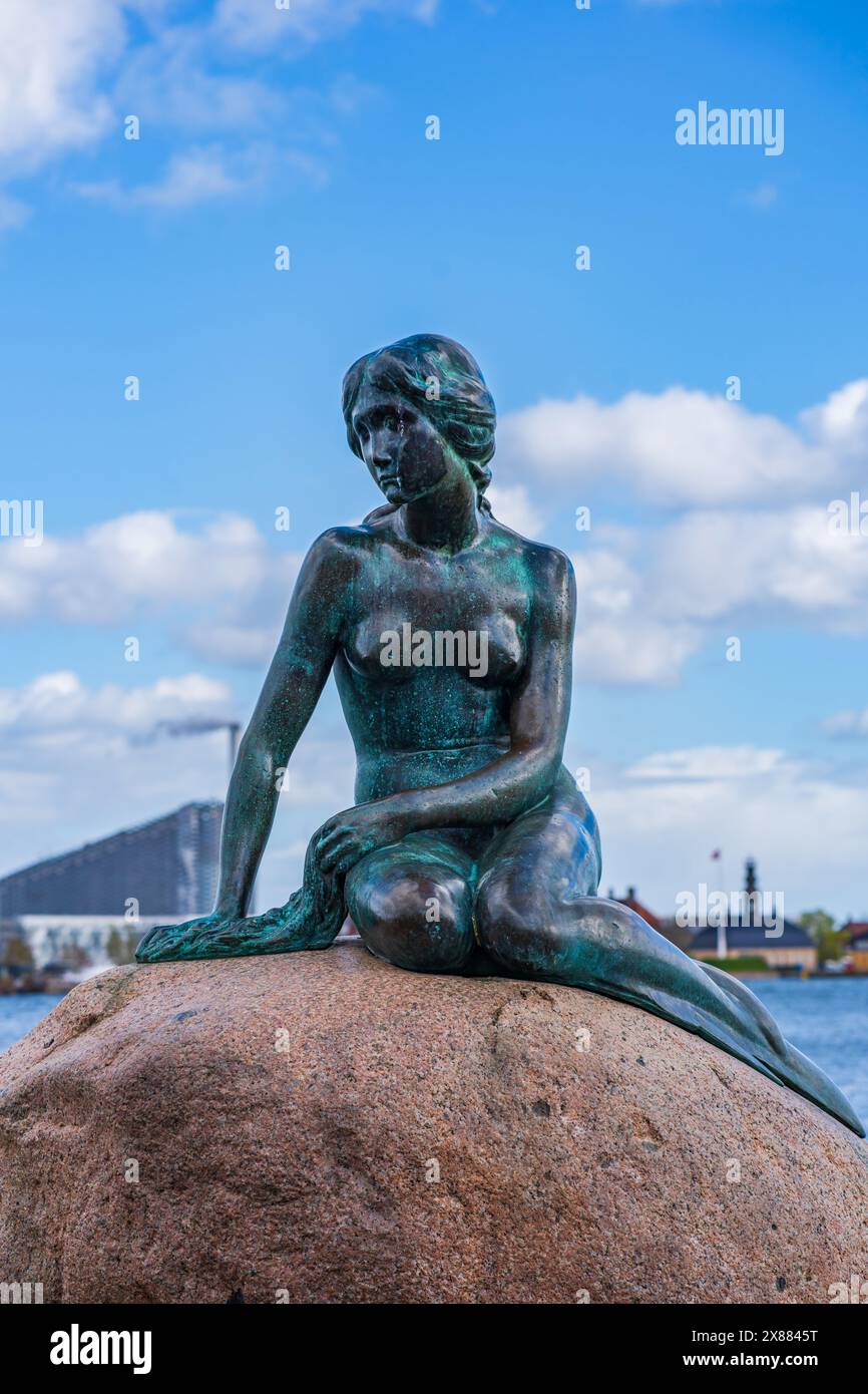 COPENHAGEN, DENMARK - APRIL 14, 2024: Bronze statue of the Little Mermaid sitting on a rock at ...