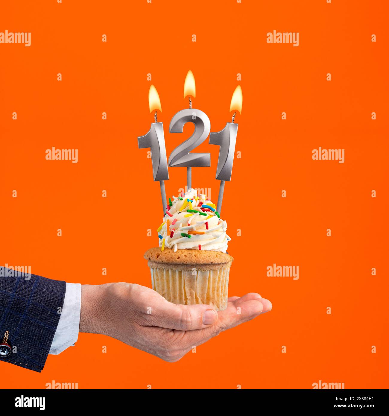 Hand holding birthday cupcake with number 121 candle - background ...