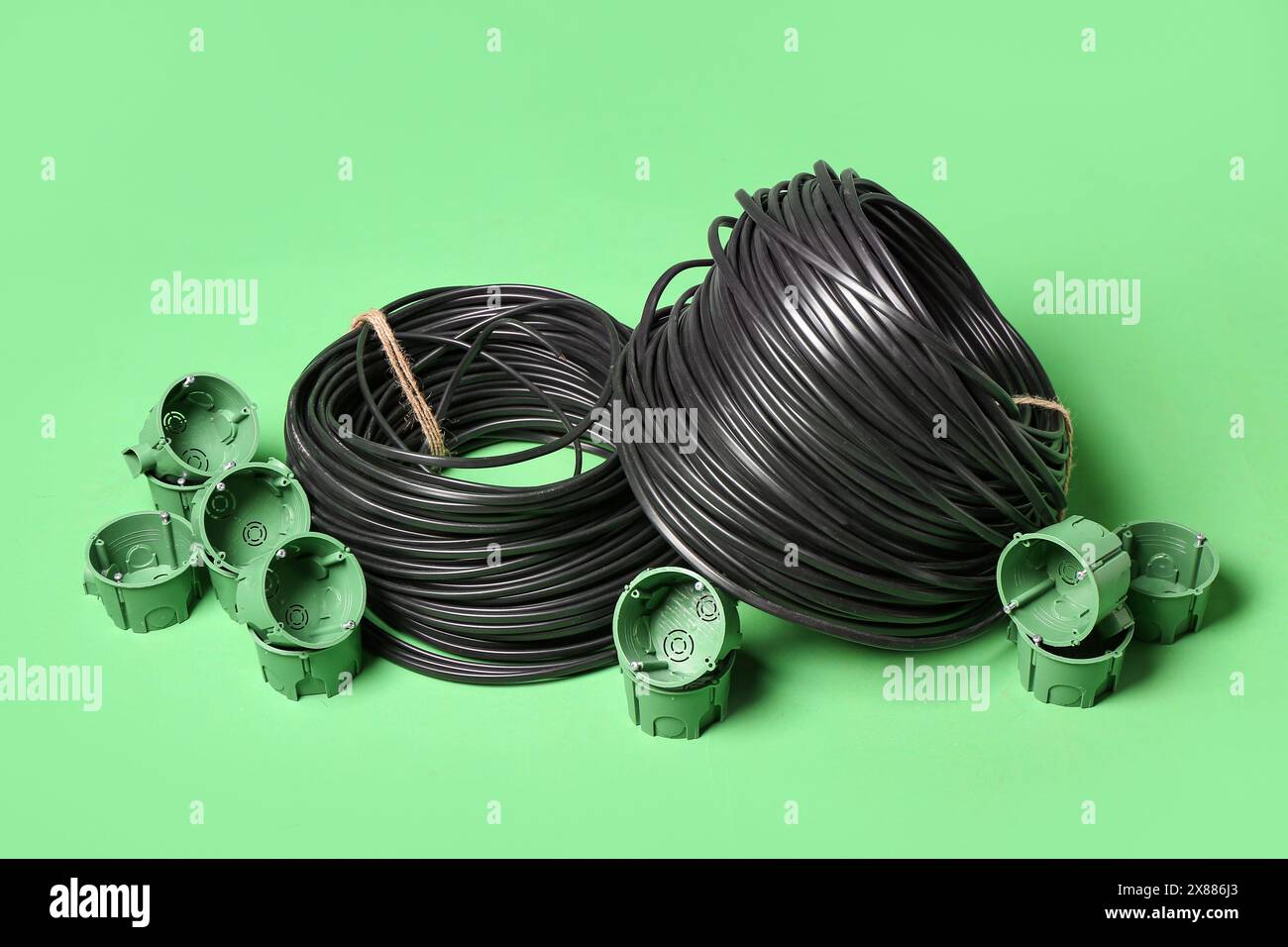 Rolled cables and socket mounting boxes on green background Stock Photo ...