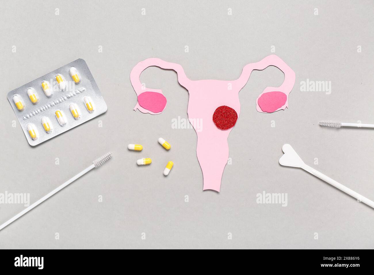 Paper uterus with pills and pap smear test tools on grey background ...