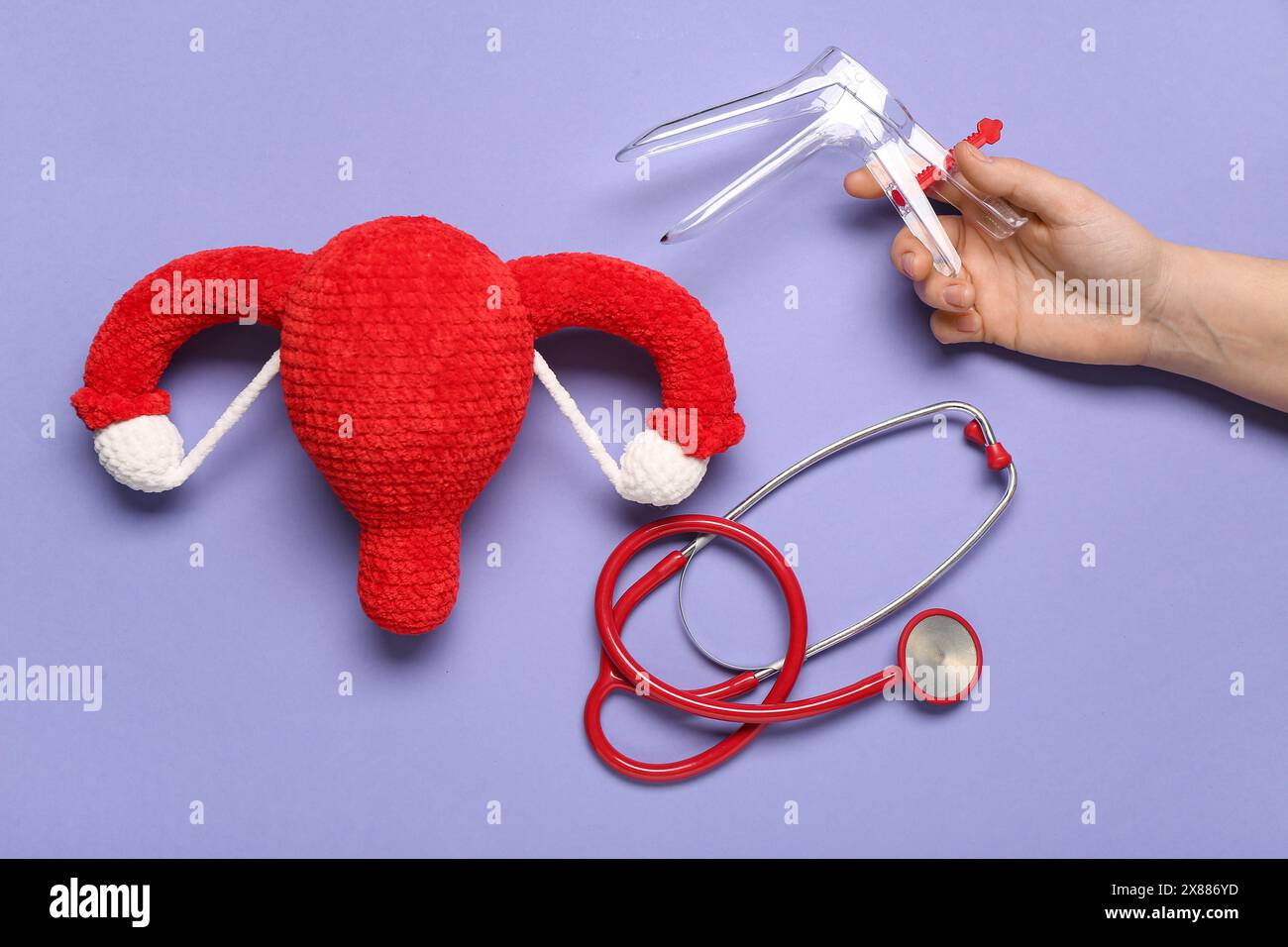 Female hand with knitted uterus, gynecological speculum and stethoscope ...