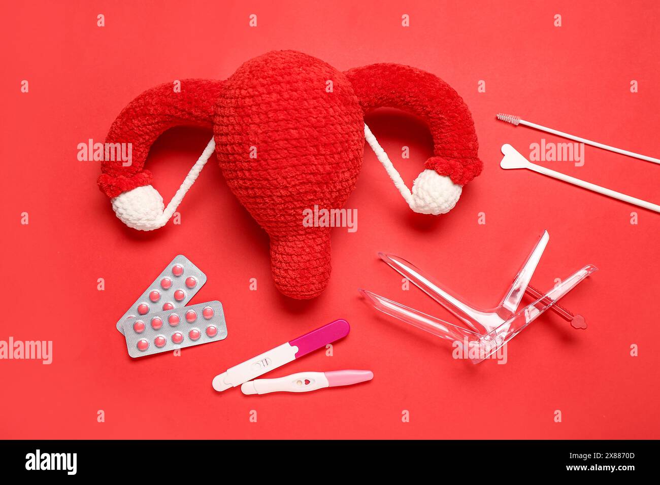 Knitted uterus with pills, pregnancy tests and gynecological speculum ...