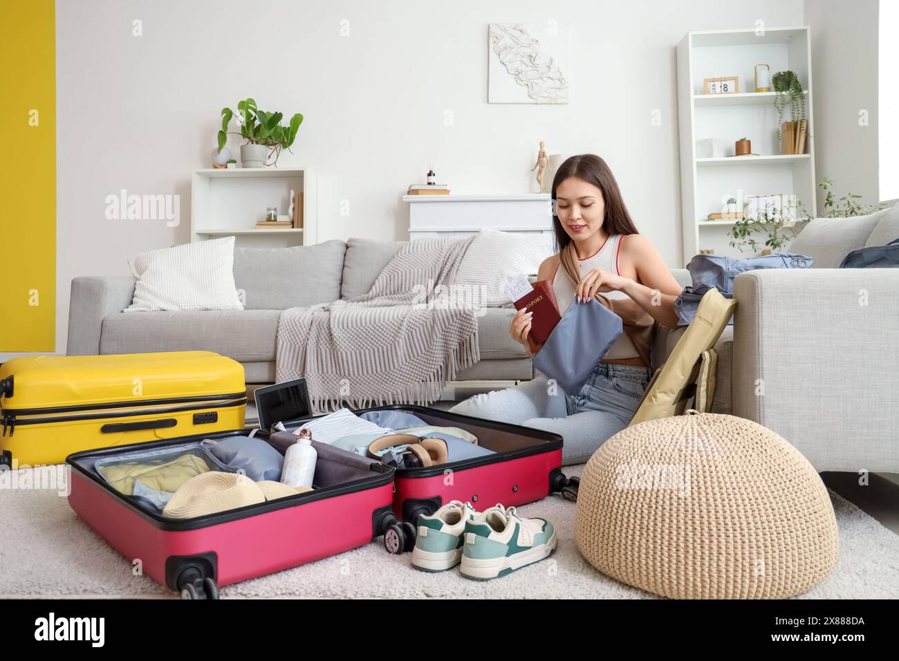 Female Asian traveler putting valuables into into organizer at home ...
