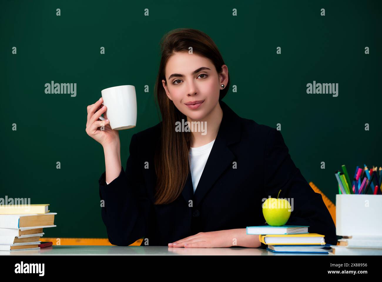 Student with cup drinking tea in classroom. Coffee break in university ...