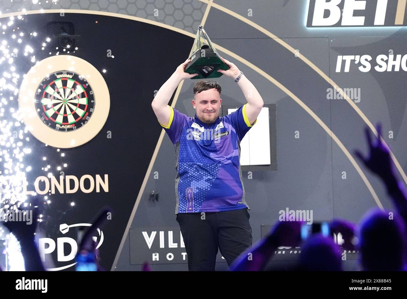 Luke Littler celebrates with the trophy after victory in the final ...