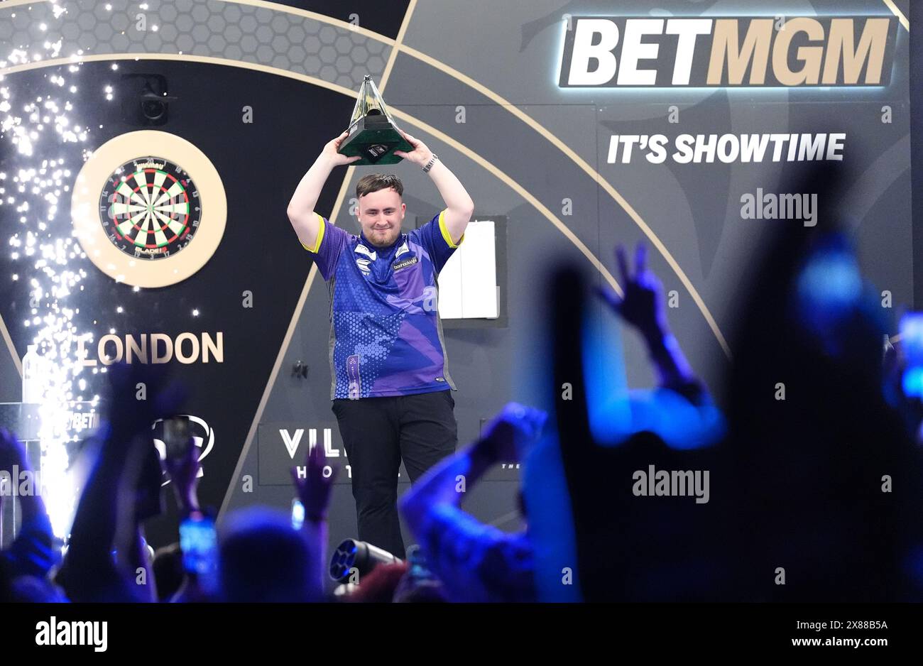 Luke Littler celebrates with the trophy after victory in the final ...