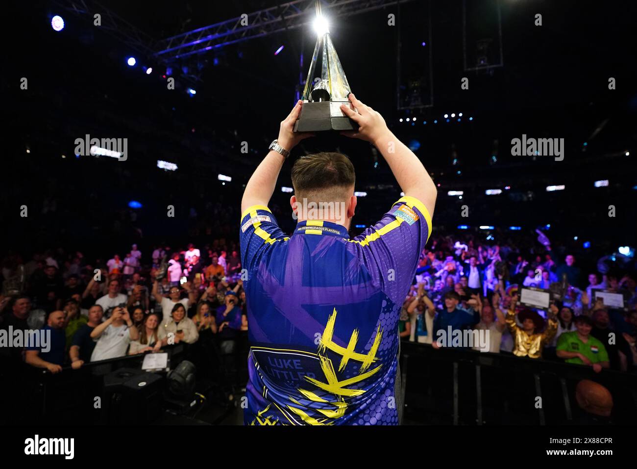 Luke Littler celebrates with the trophy in front of the crowd after ...