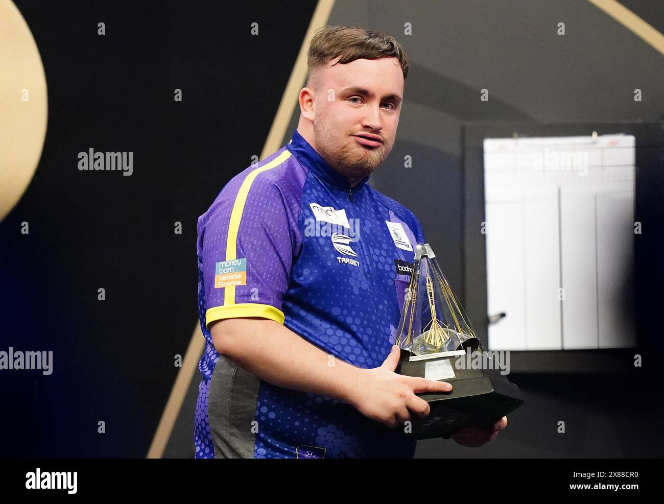 Luke Littler celebrates with the trophy after victory in the final ...