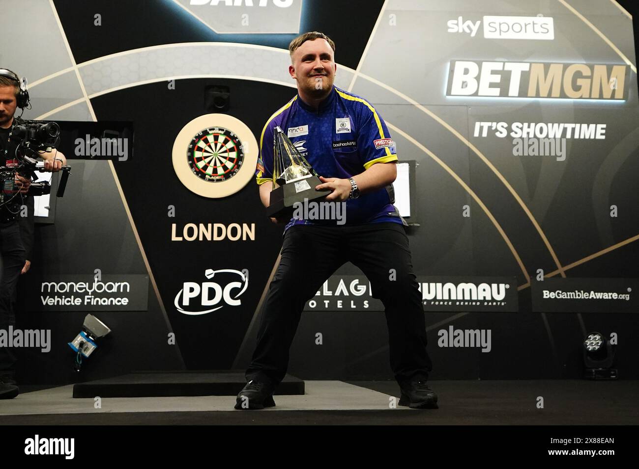 Luke Littler celebrates with the trophy after victory in the final ...