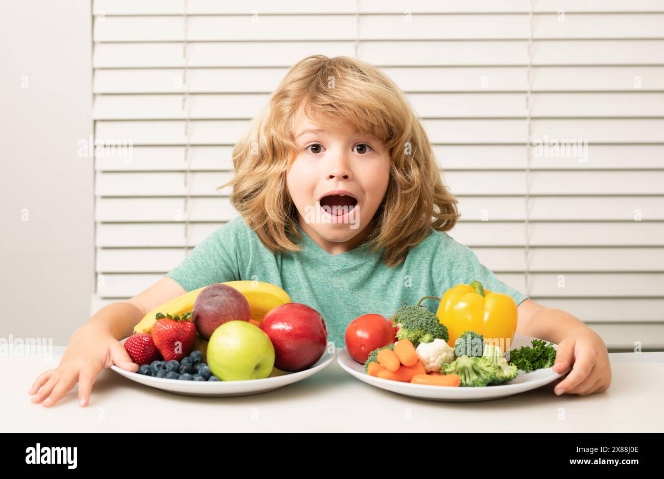 Portrait of preteen child eat fresh healthy food in kitchen at home ...