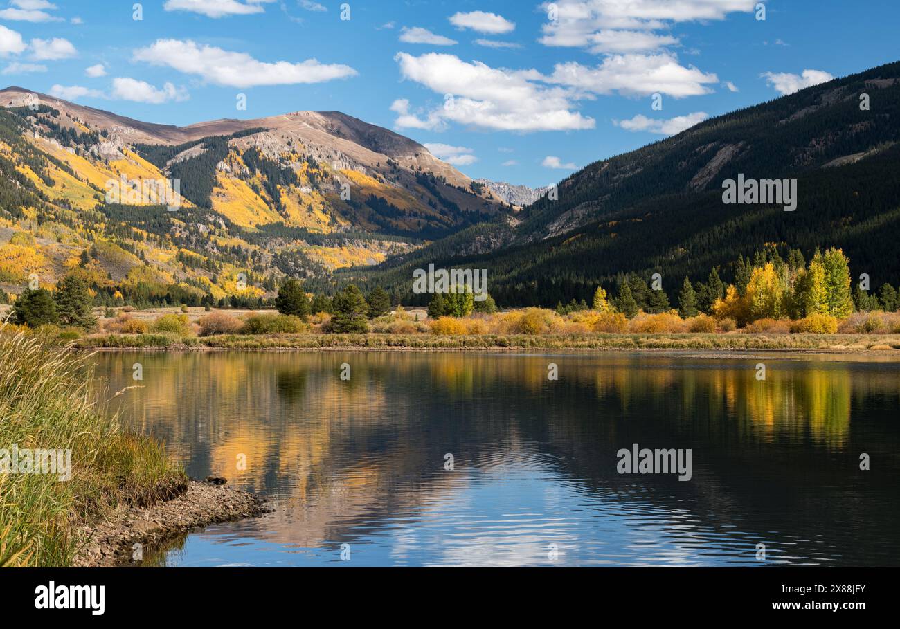 Camp Hale Pond with reflections of surrounding mountains and autumn ...