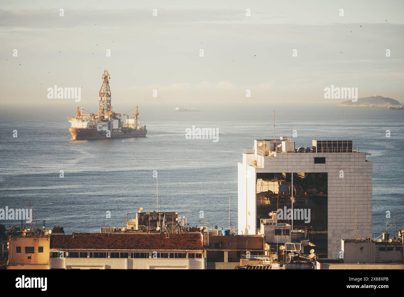 An offshore oil rig stands majestically in the open sea at dawn, viewed ...